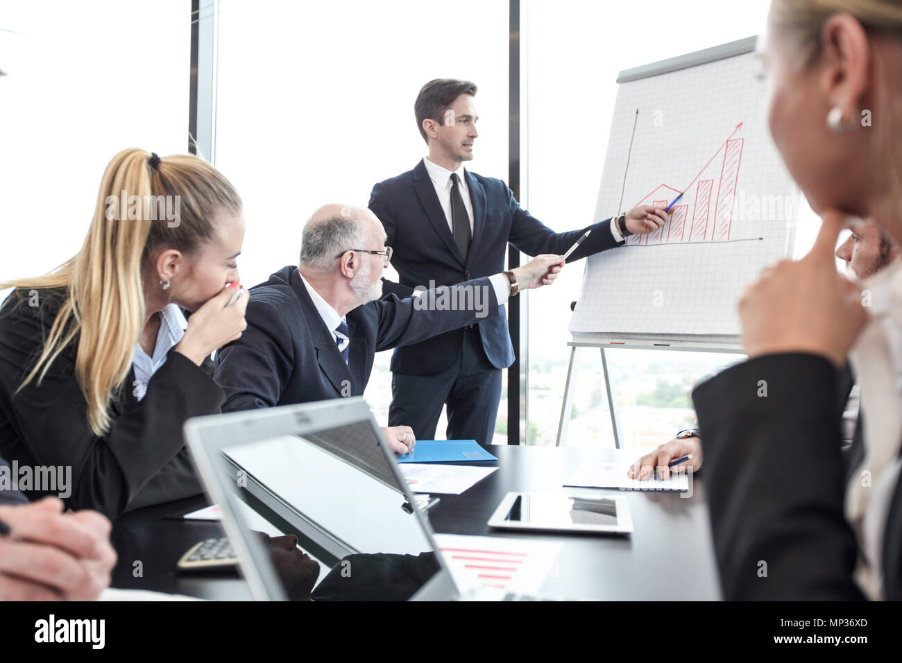 Group of business people working with presentation on flipchart showing ...