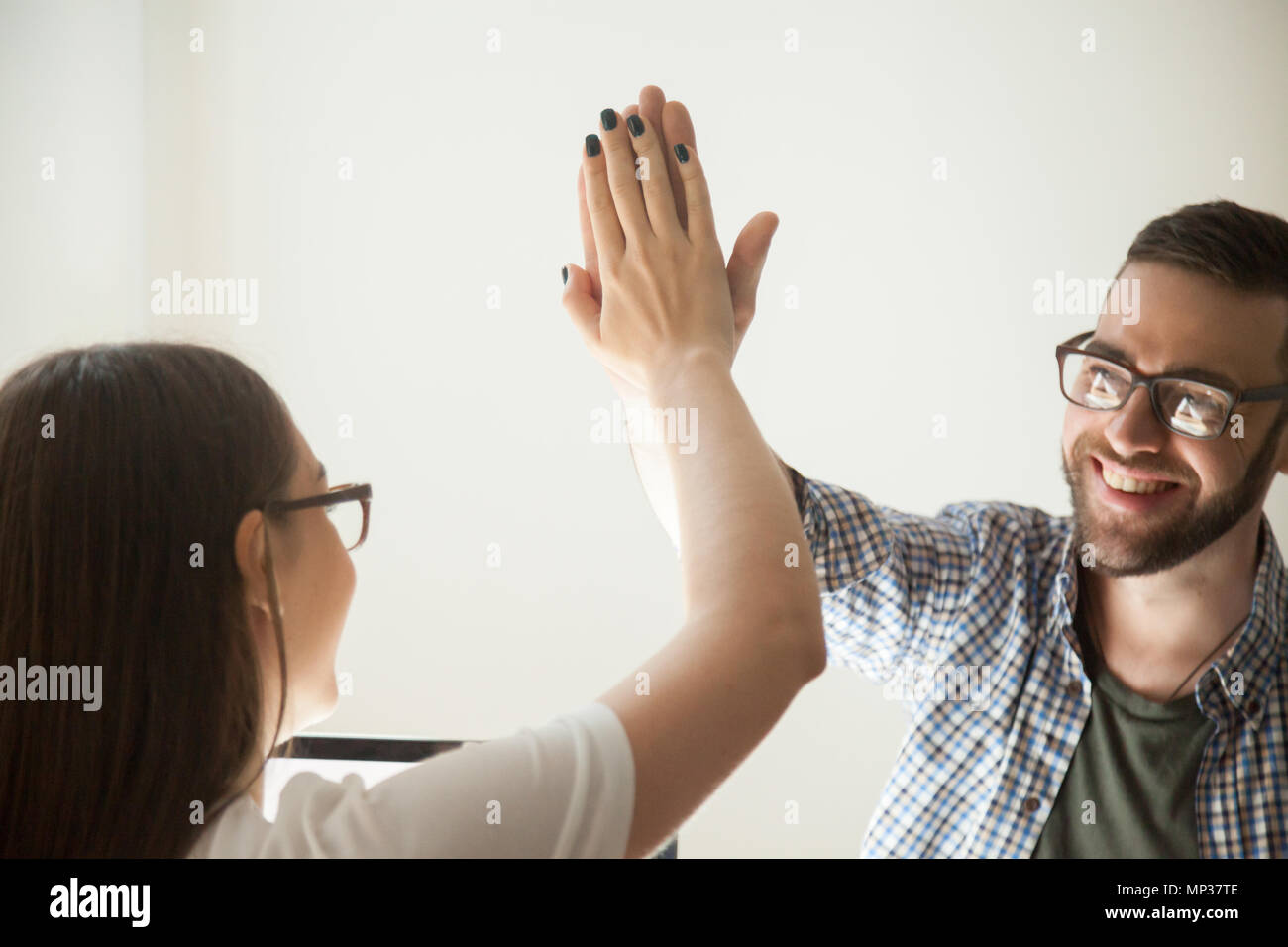 Smiling workers giving high five after company business success Stock ...
