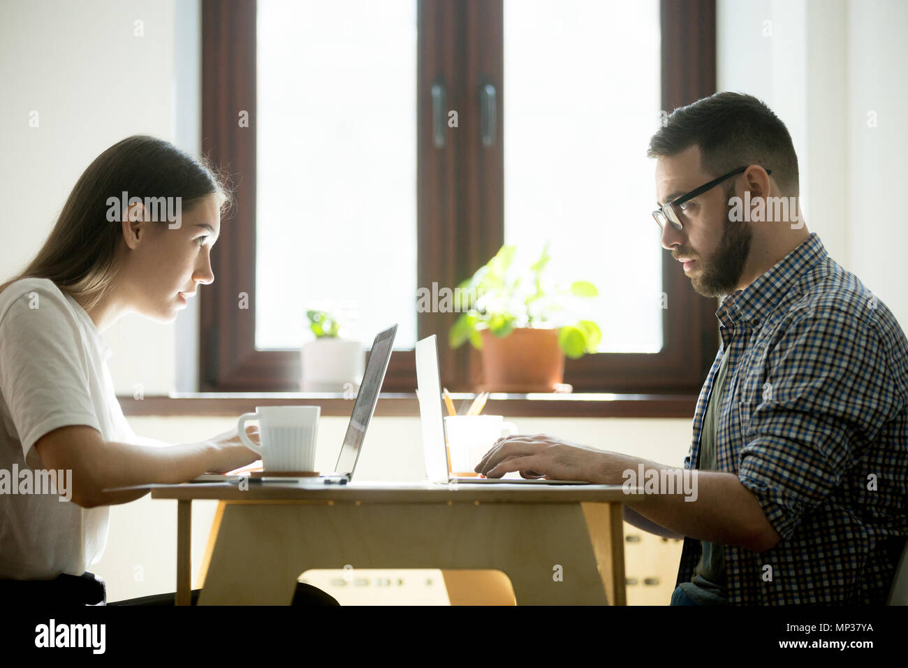 Work rivals looking at each other with jealousy and dislike Stock Photo ...