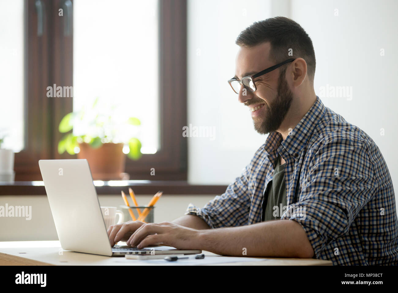 Happy male writing positive mail to client Stock Photo - Alamy