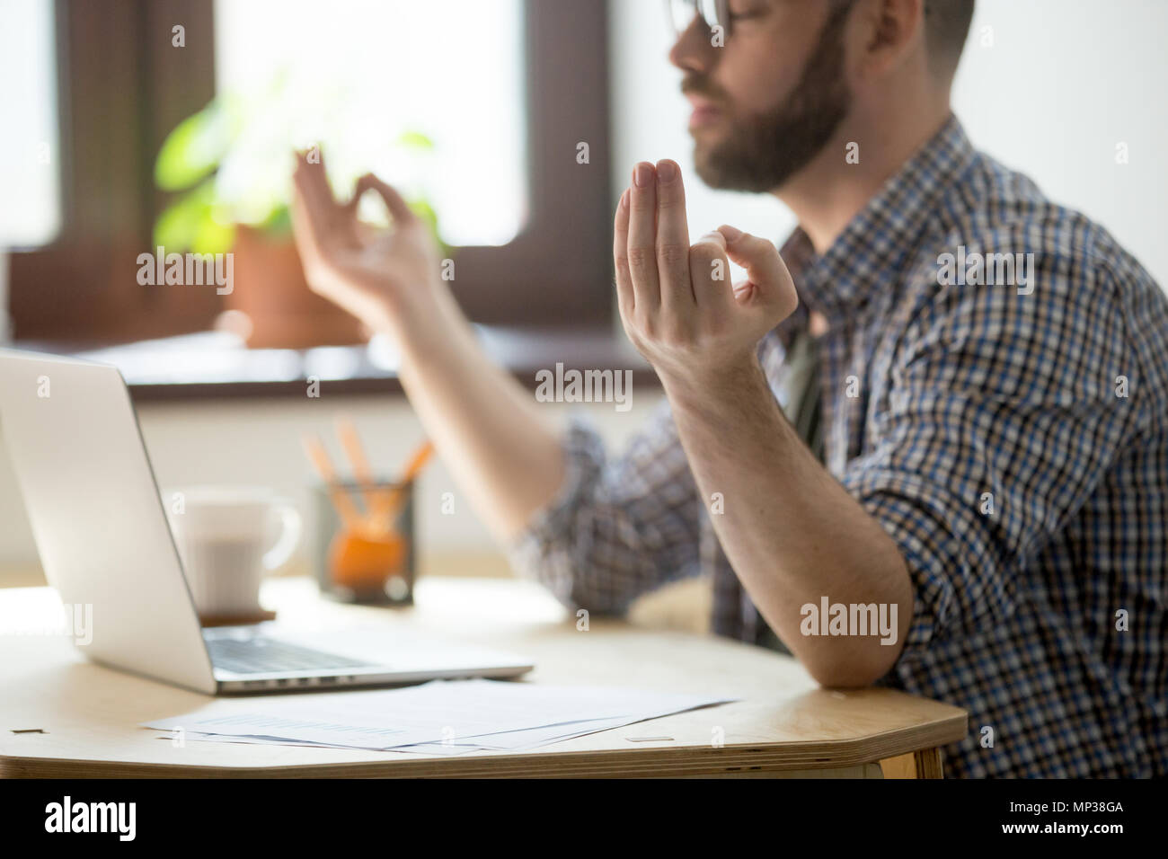 Concentrated male meditating in office relieving stress Stock Photo - Alamy