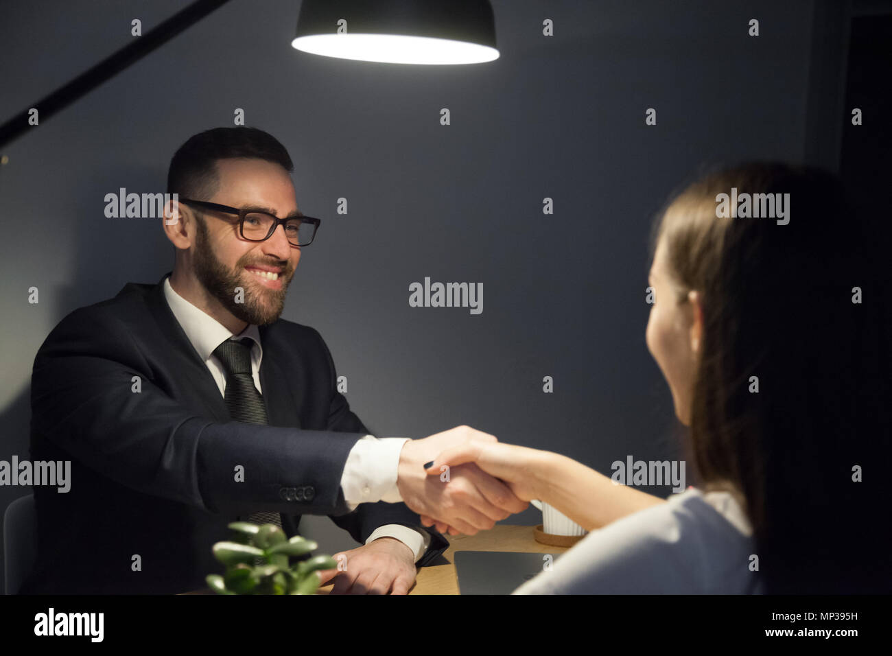 Happy male shaking hand of female job applicant during interview Stock ...