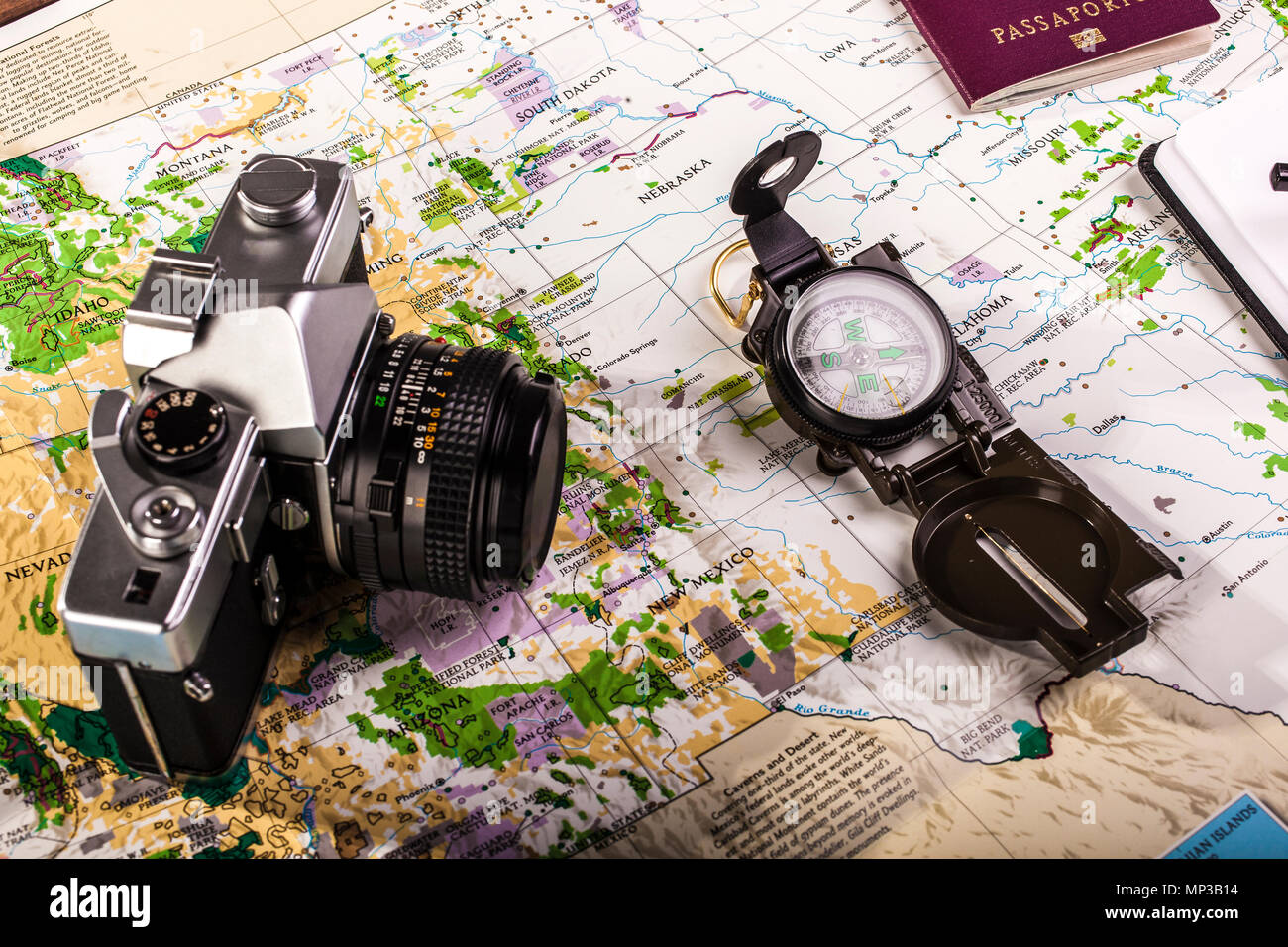Travel planning. Compass, passport, photo camera and block notes on map ...
