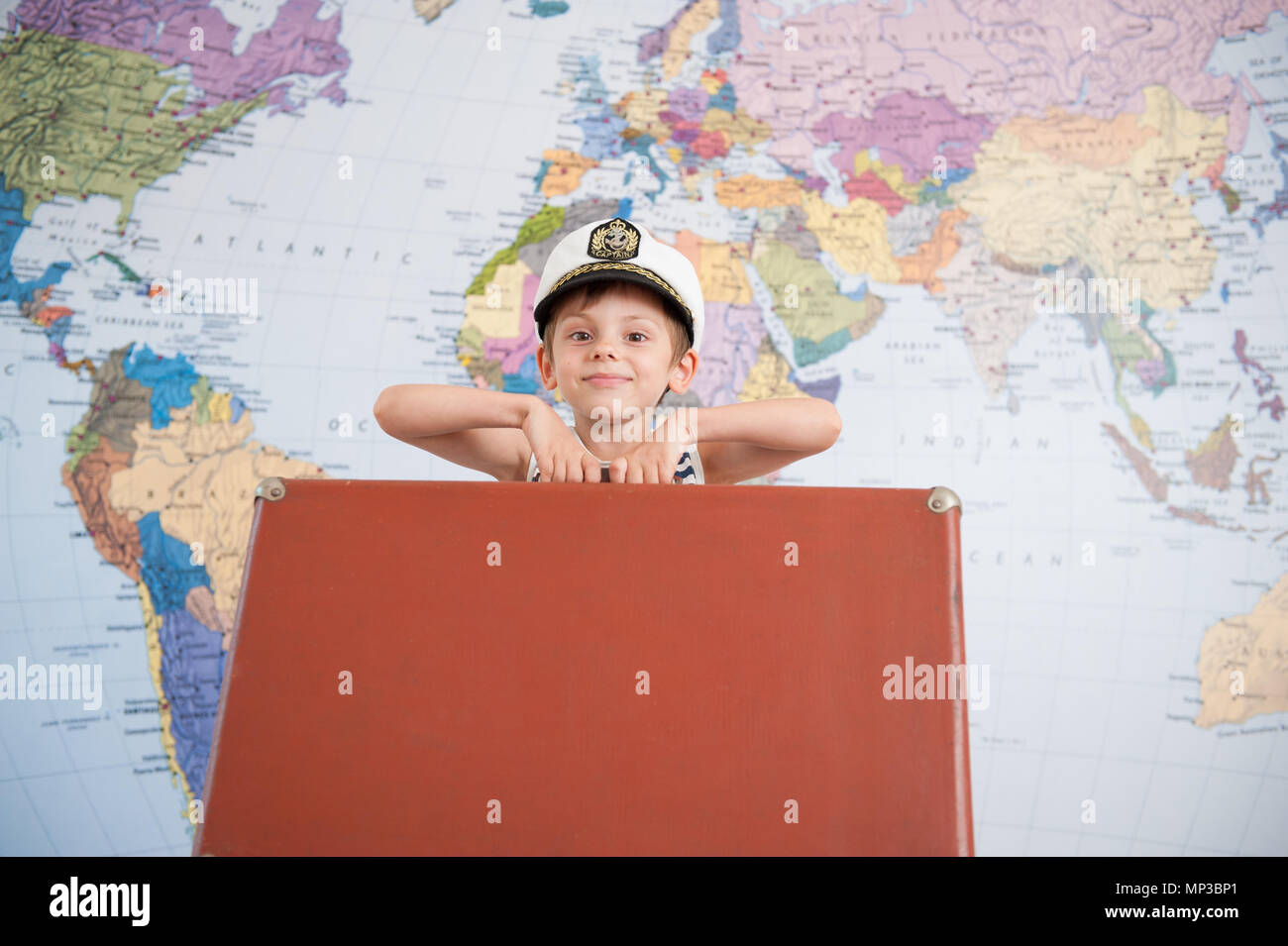 happy smiling little kid in captain hat lifting travel suitcase on ...