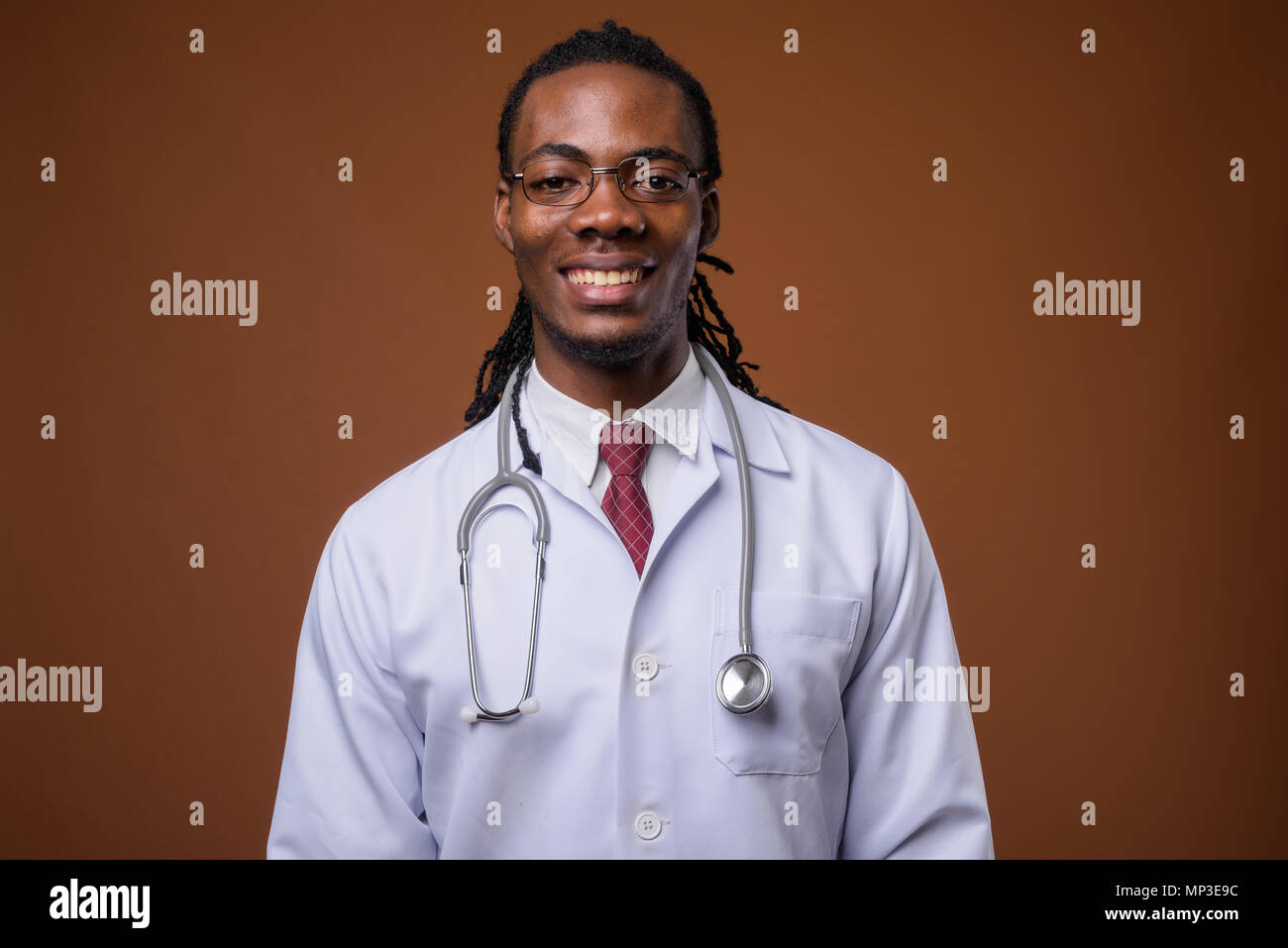 Young handsome African man doctor against brown background Stock Photo ...
