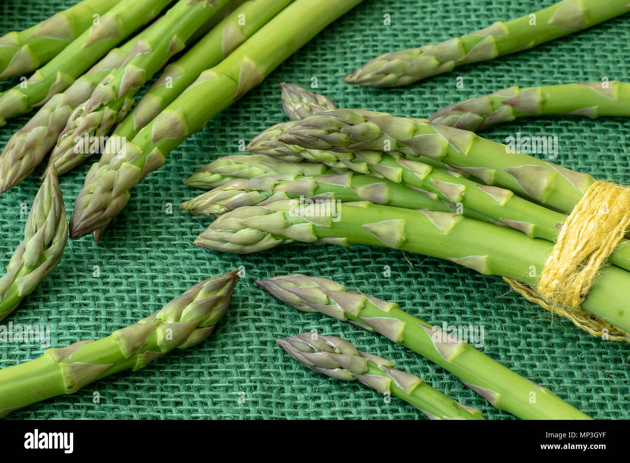 Raw garden asparagus stems. Fresh green spring vegetables on green ...