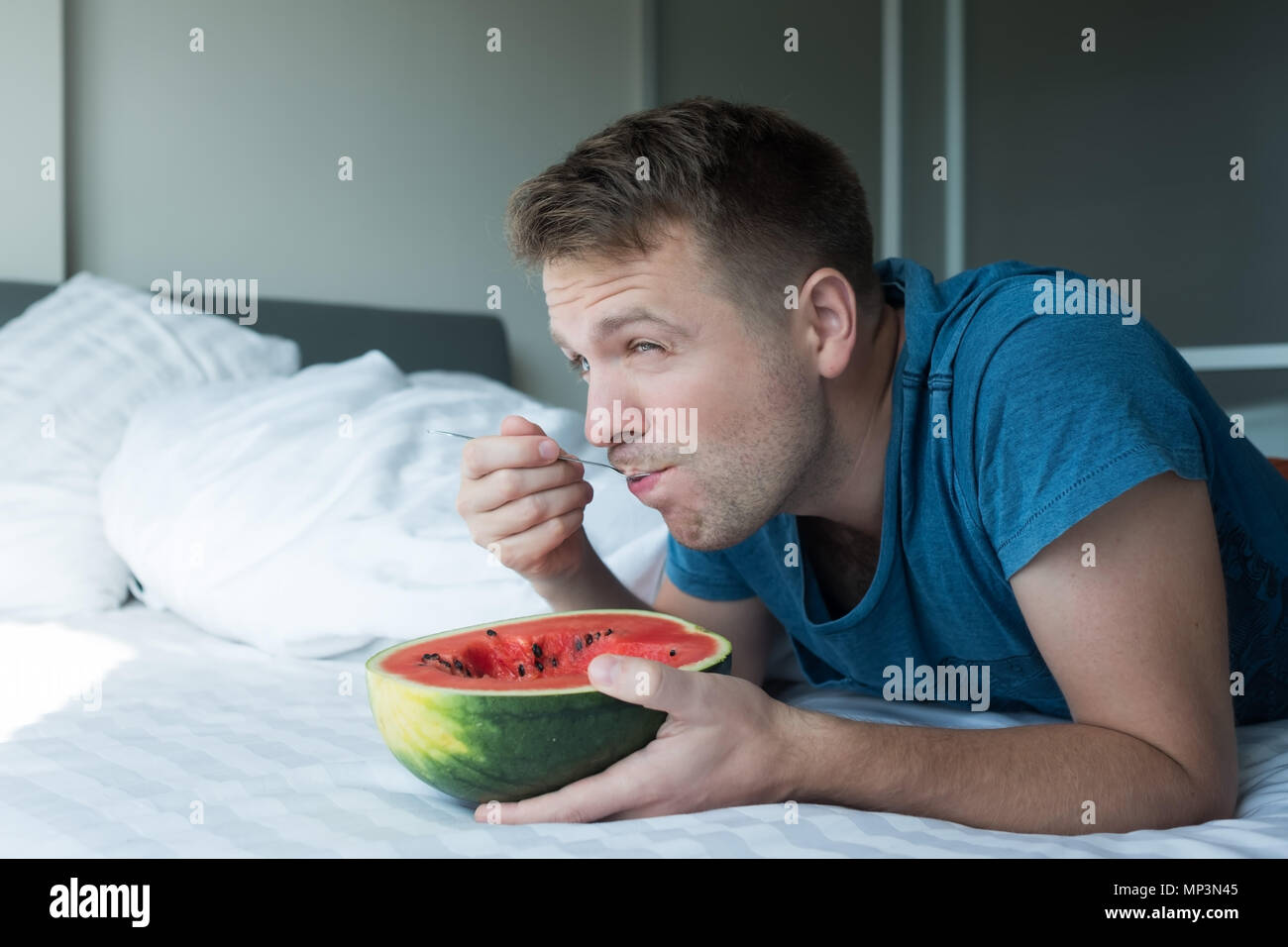 Caucasian man eating watermelon at home Stock Photo - Alamy