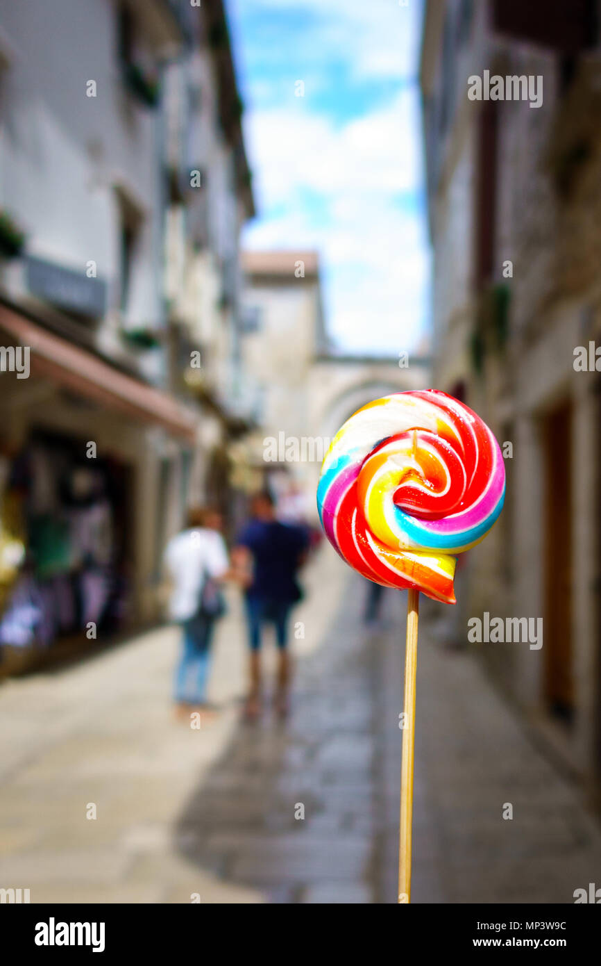 Colorful lolipop, old city street blurred as background Stock Photo - Alamy