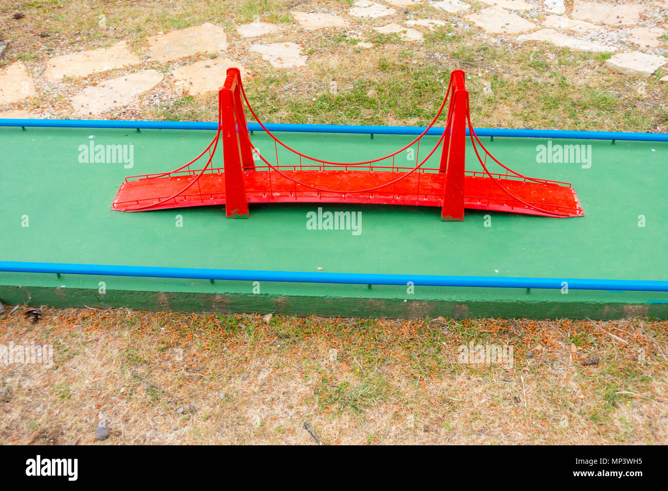 Mini golf course with obstacles, red suspension bridge Stock Photo - Alamy