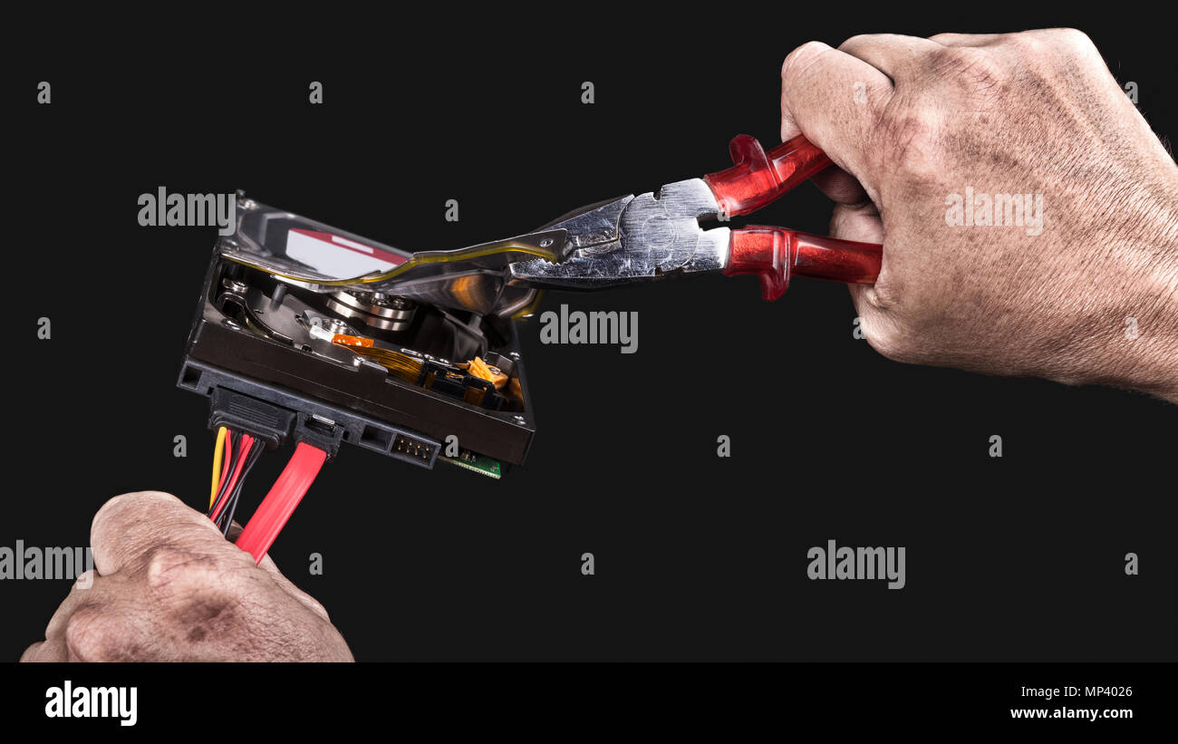 Hard disk drive and pliers in human hands. Black background. Open ...