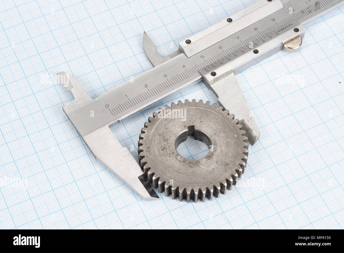 gear and caliper on graph paper background Stock Photo - Alamy