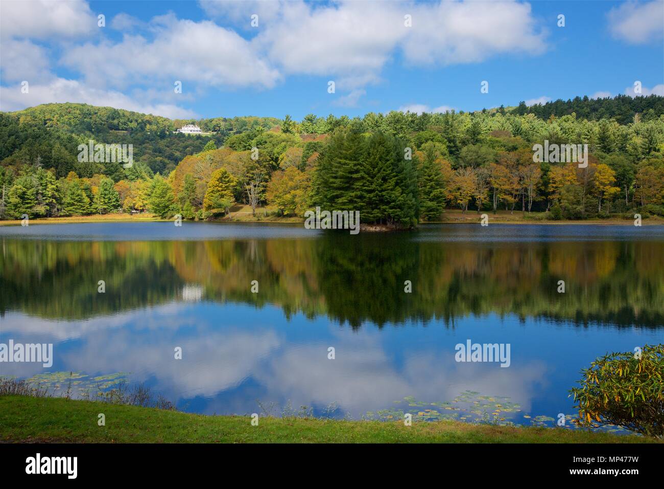 Bass Lake reflects the Moses Cone manor and Fall colors on a perfect ...