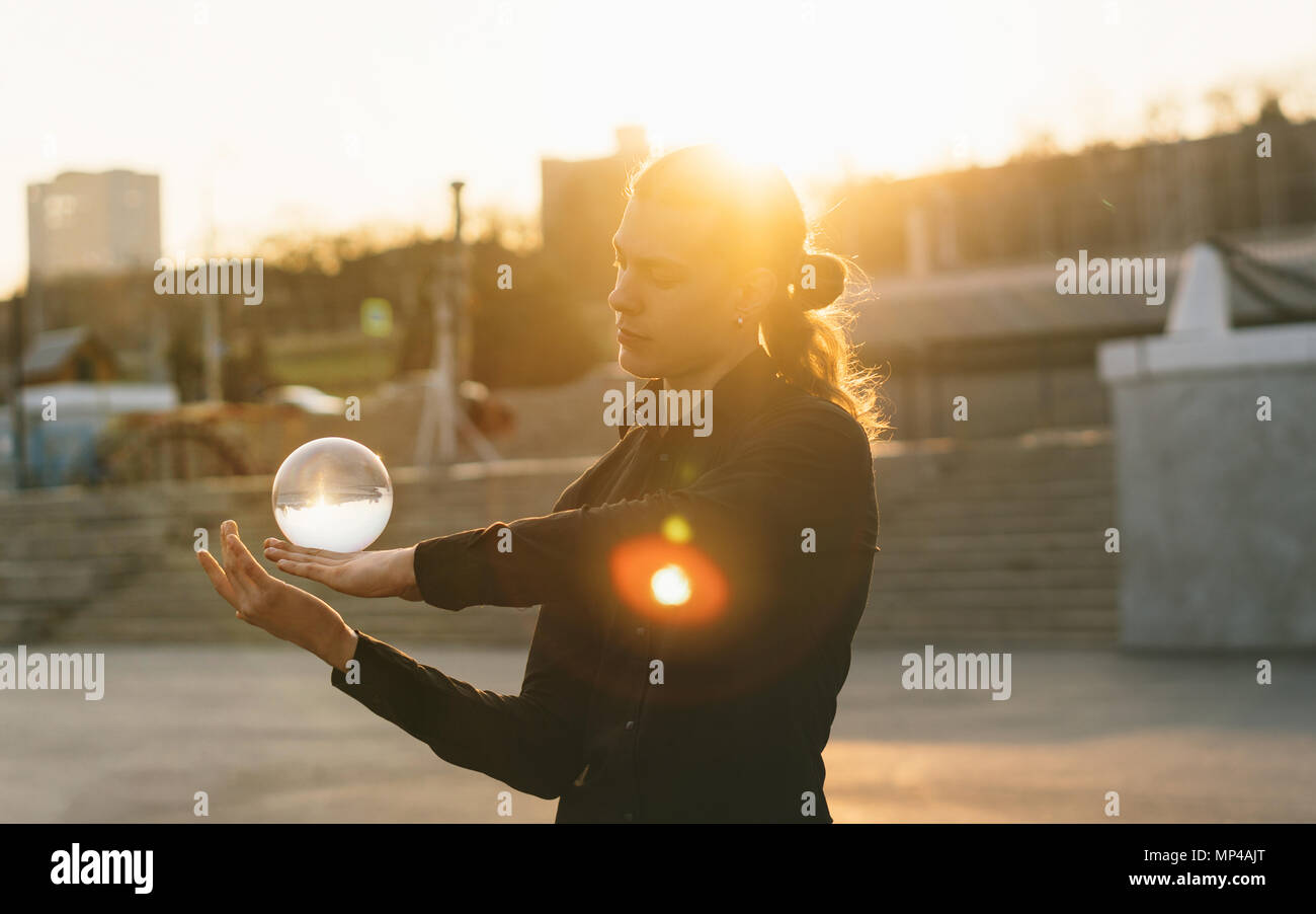 Contact juggling. Guy balances with glass ball on his hands. Inverted ...