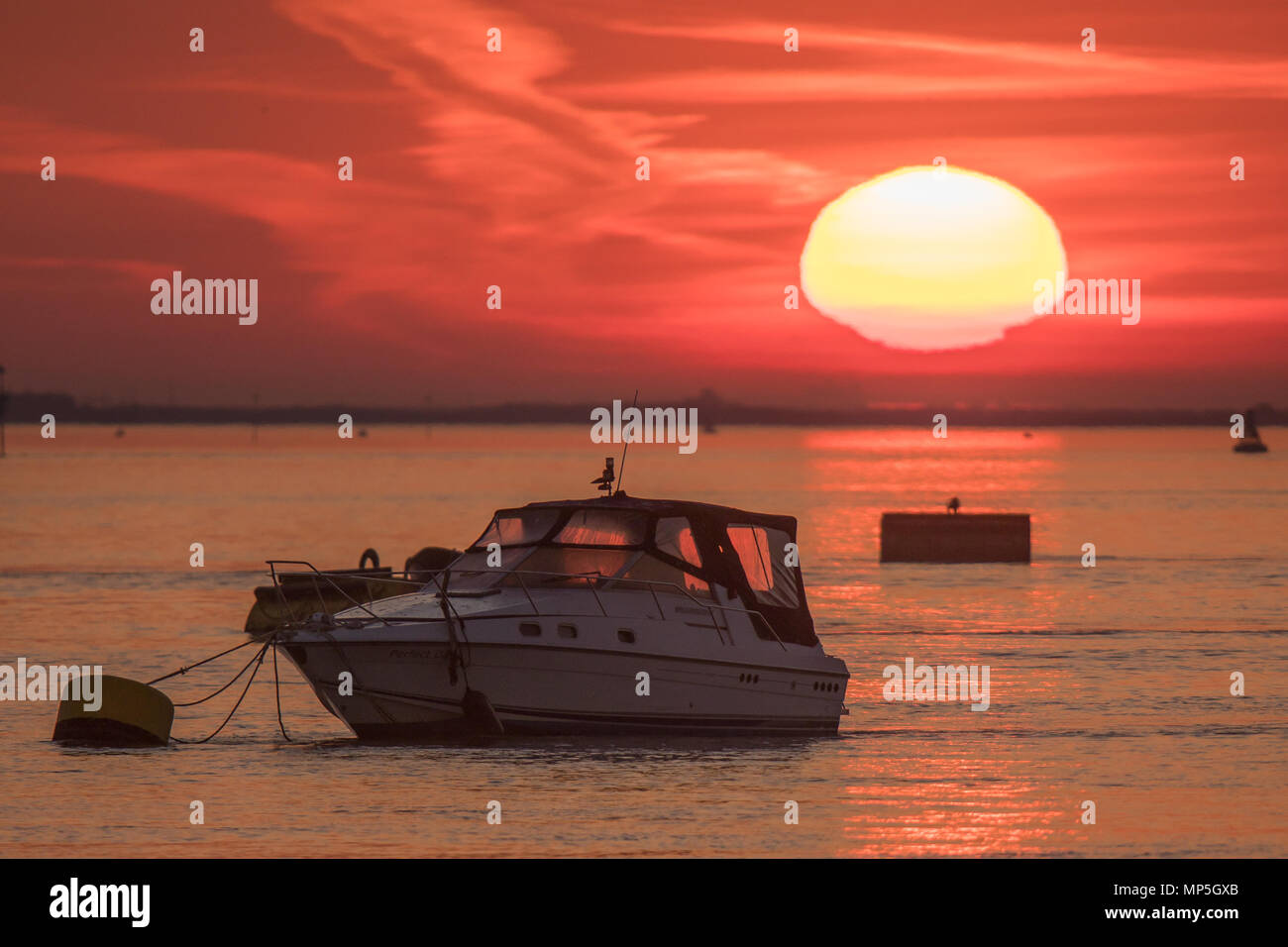 The sun rises on the Thames behind Tugs and other small boats this ...