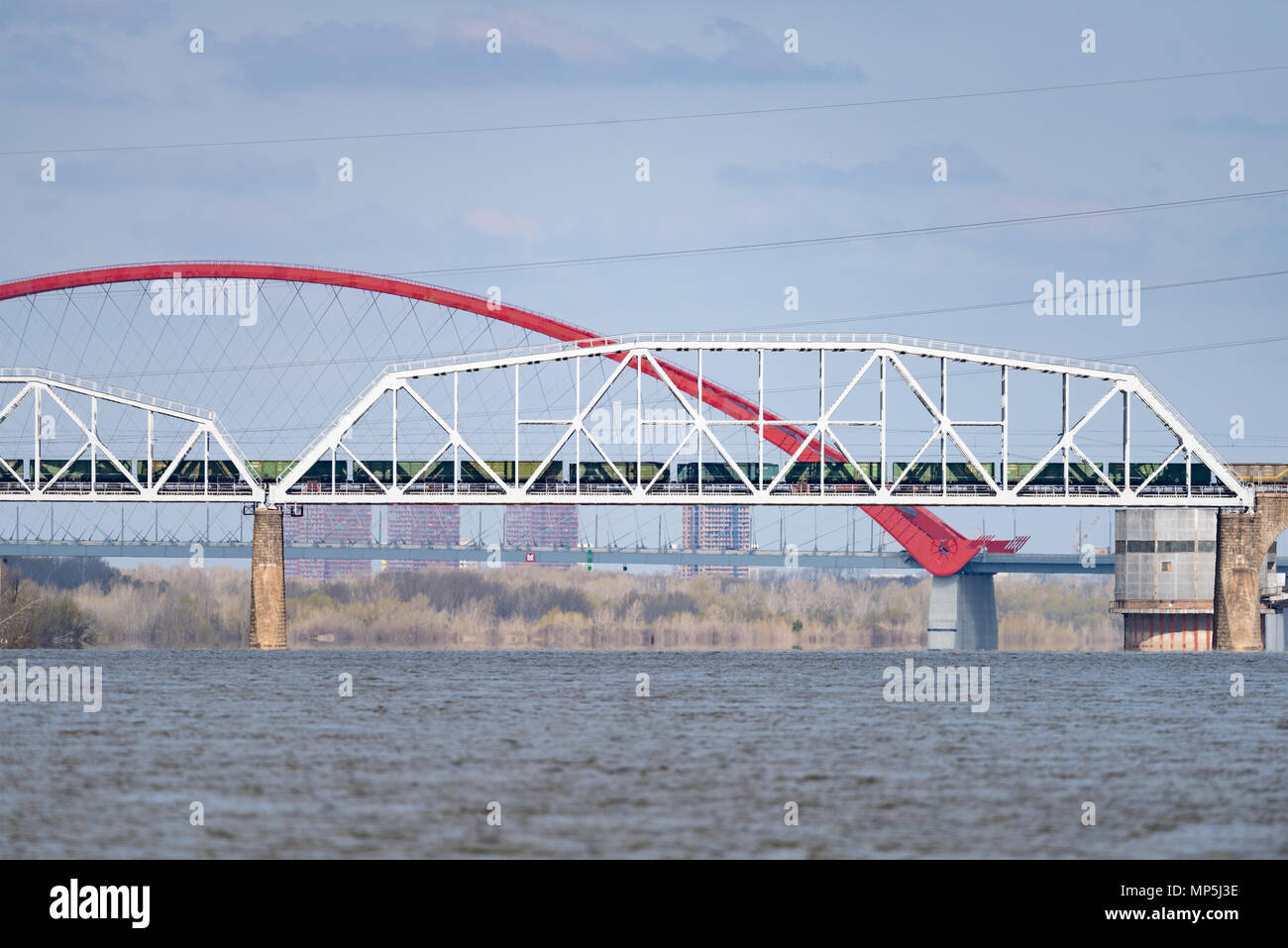 a freight train is driving across a bridge across the river Stock Photo ...