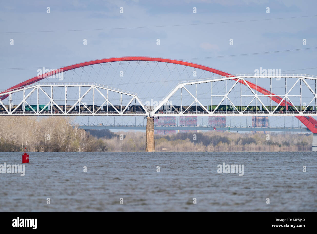 a freight train is driving across a bridge across the river Stock Photo ...