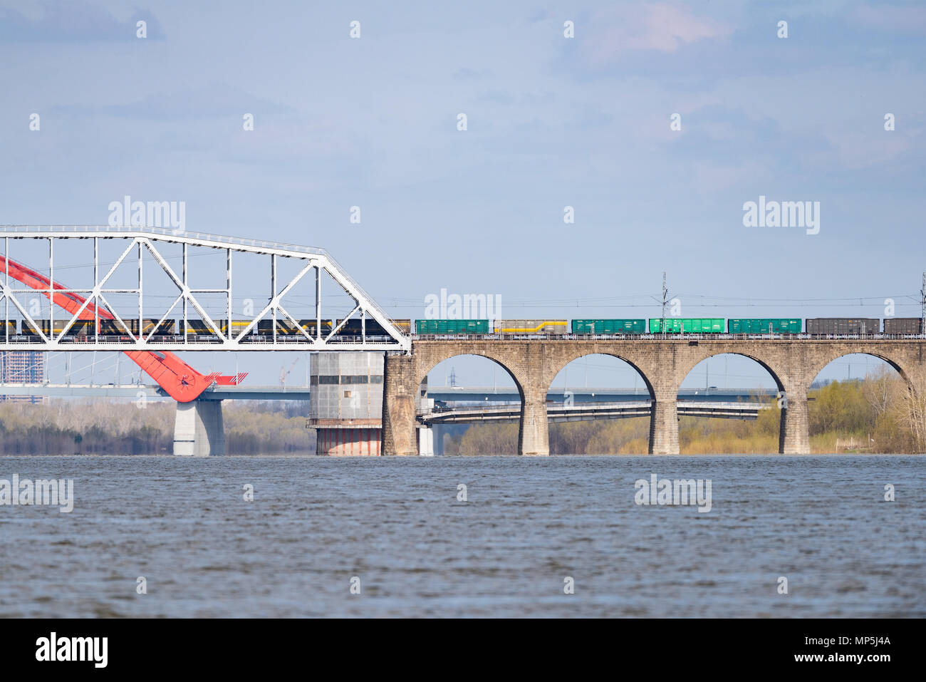 a freight train is driving across a bridge across the river Stock Photo ...
