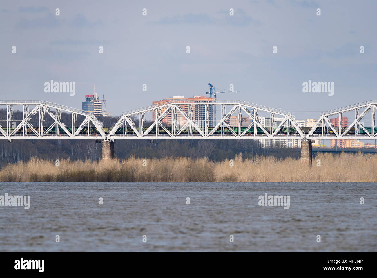 a freight train is driving across a bridge across the river Stock Photo ...