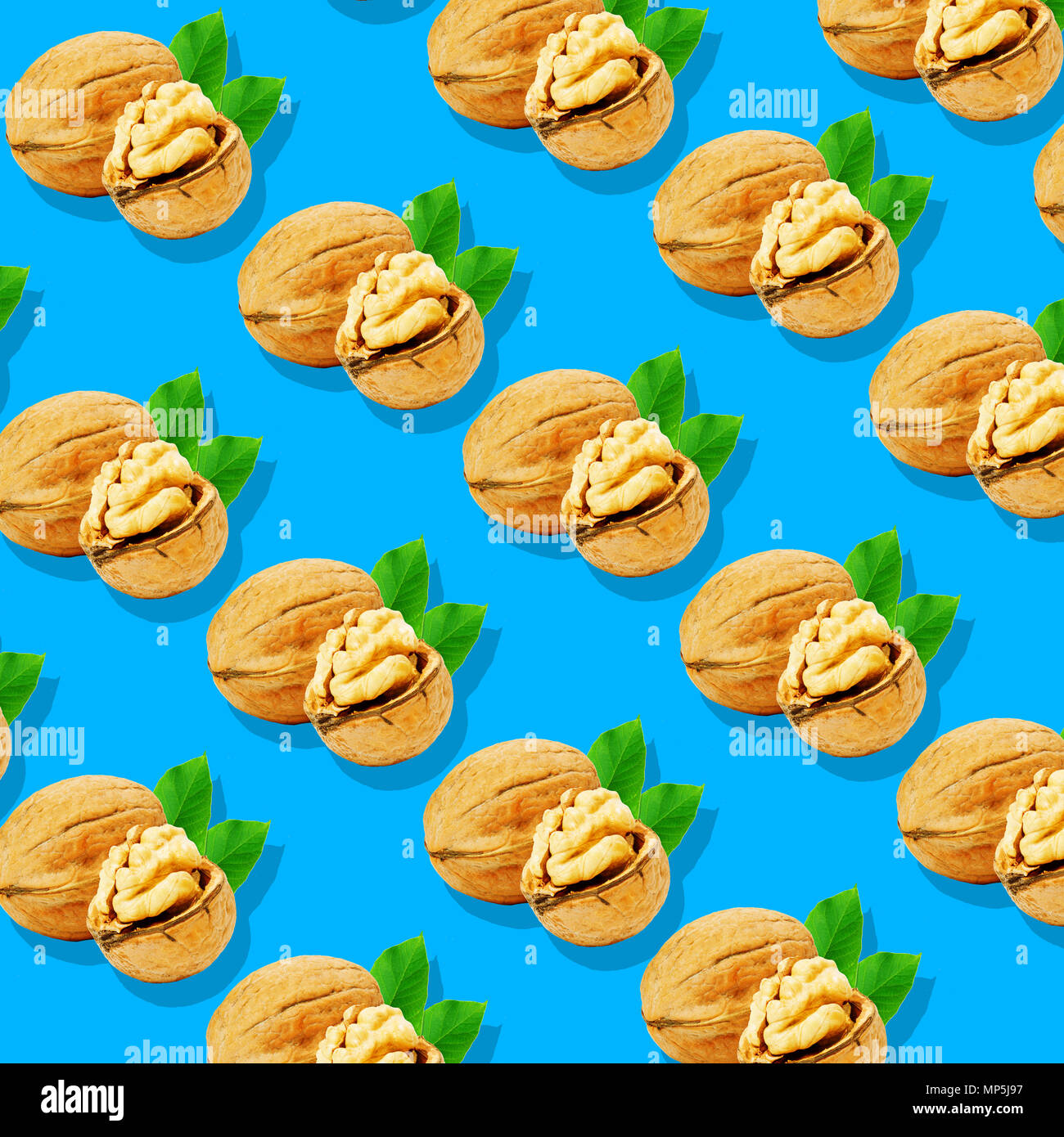 Walnuts with leaf pattern on pastel blue background. Minimal fruit ...