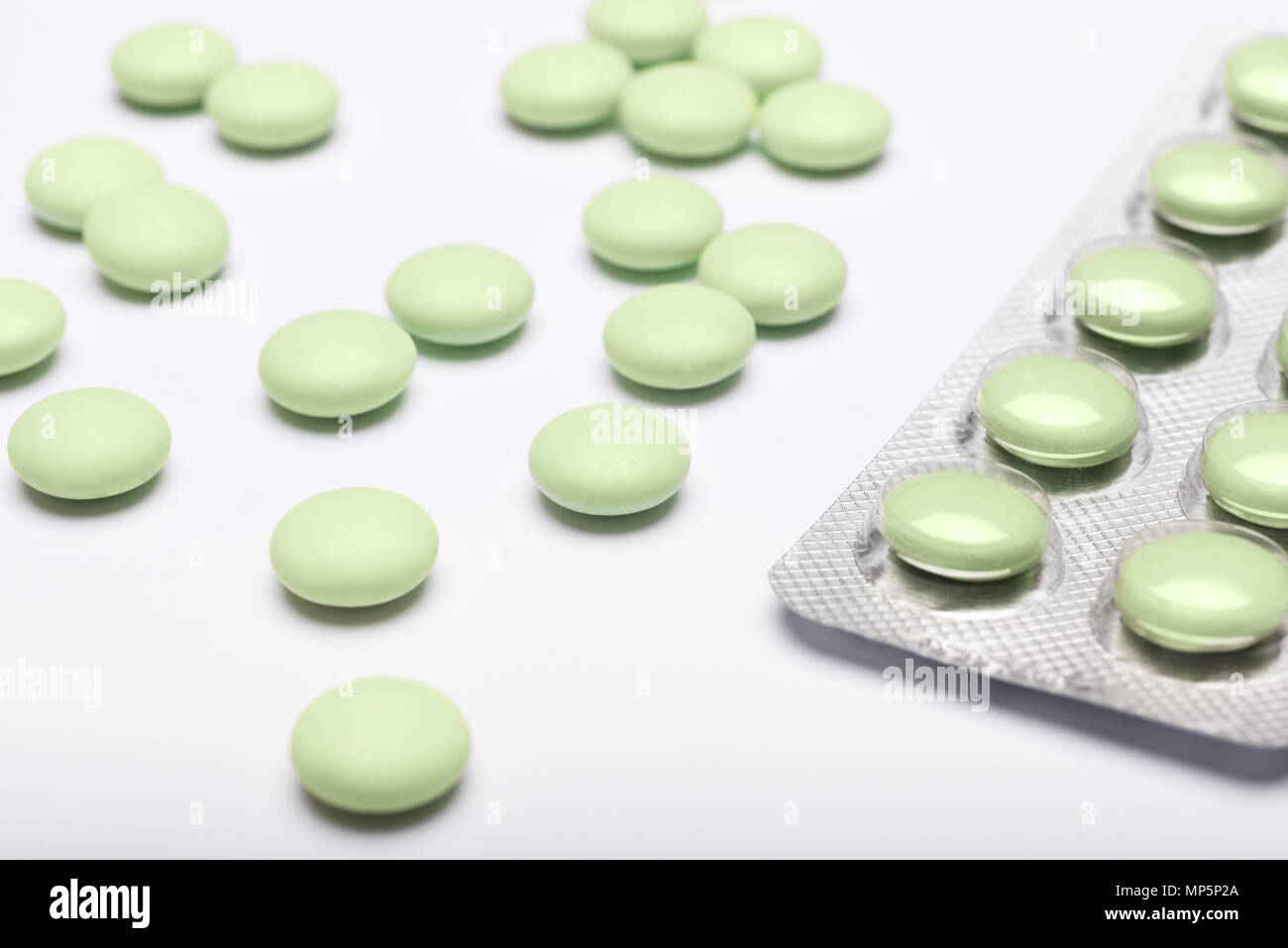 Green pills and blister pack on white background. Pharmaceutical ...