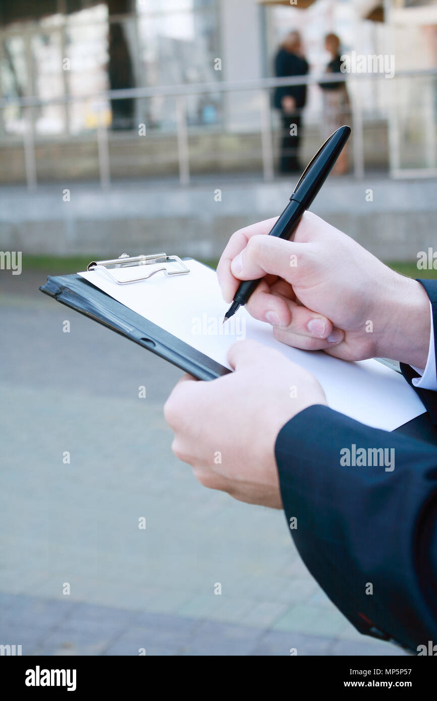 close up. businessman making notes on the clipboard Stock Photo - Alamy