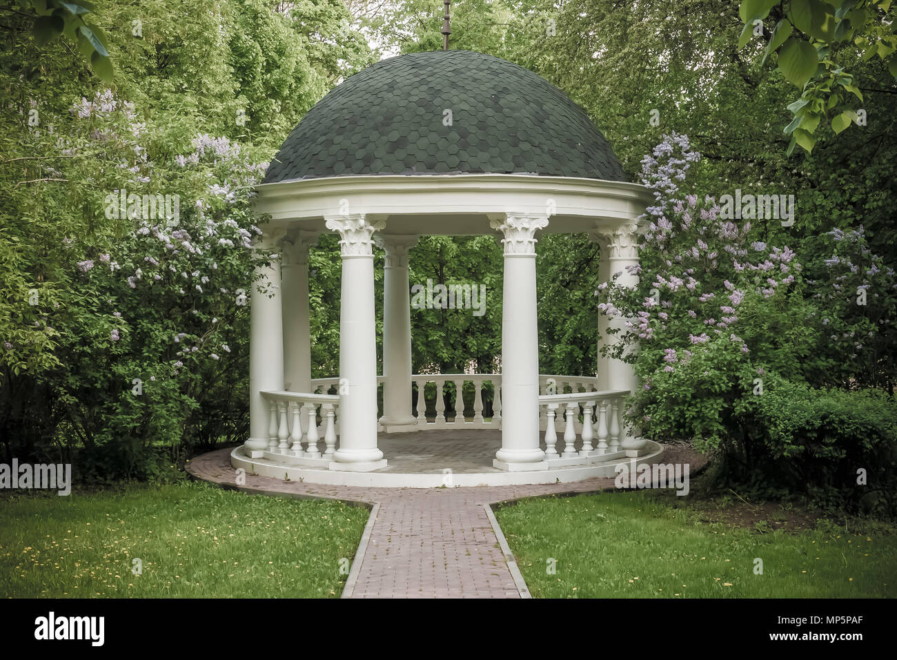 Beautiful white gazebo in a blooming spring Park Stock Photo - Alamy