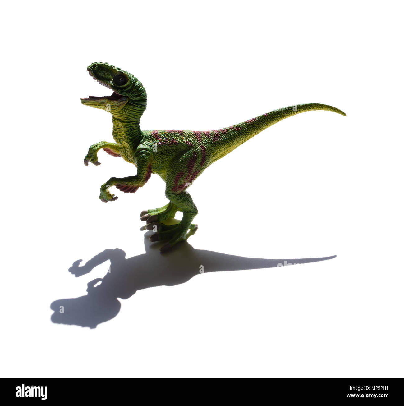 yellow velociraptor toy on a white background with shadow Stock Photo ...