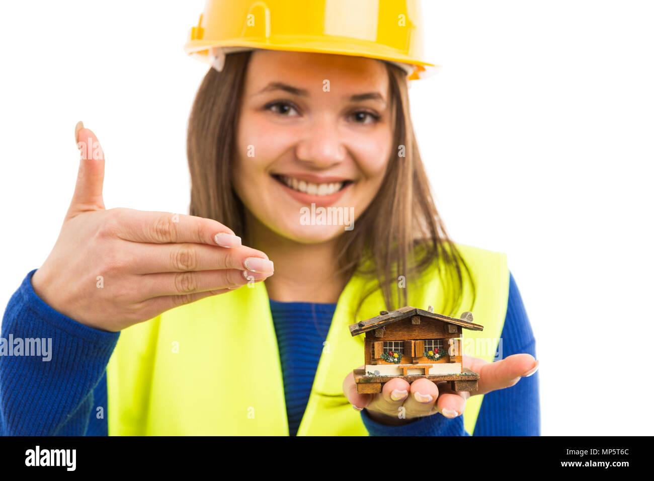 Young female architect or engineer holding miniature house and ...