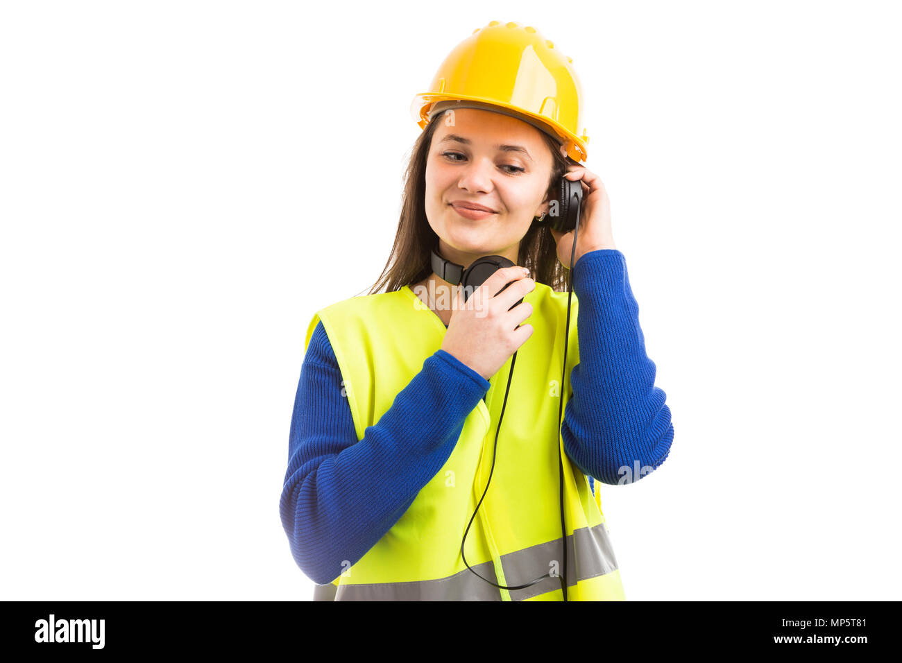 Young female engineer or architect listening to music in headphones as ...