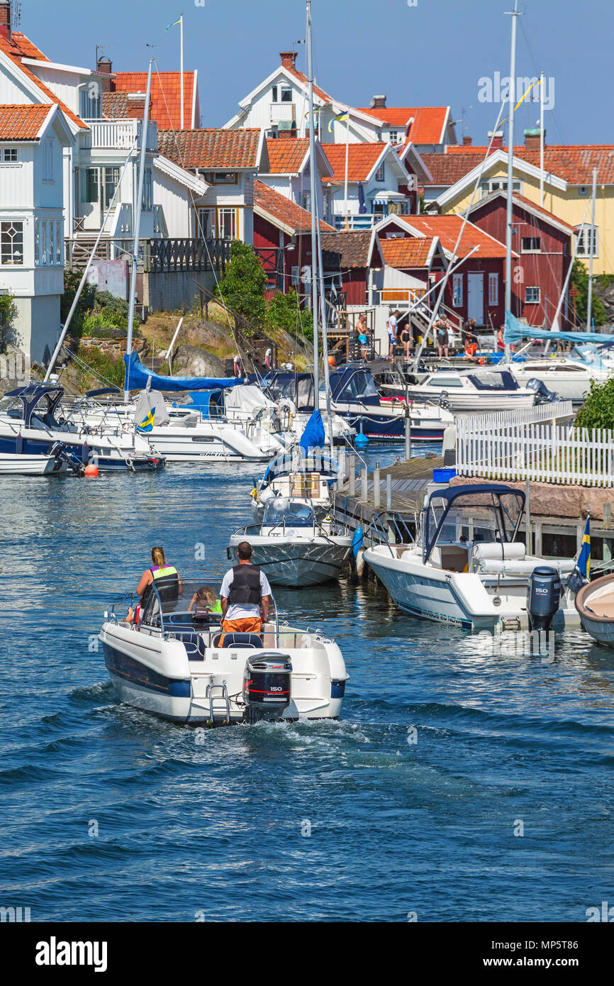 Boats entering the narrow sea channel between the boats and houses ...