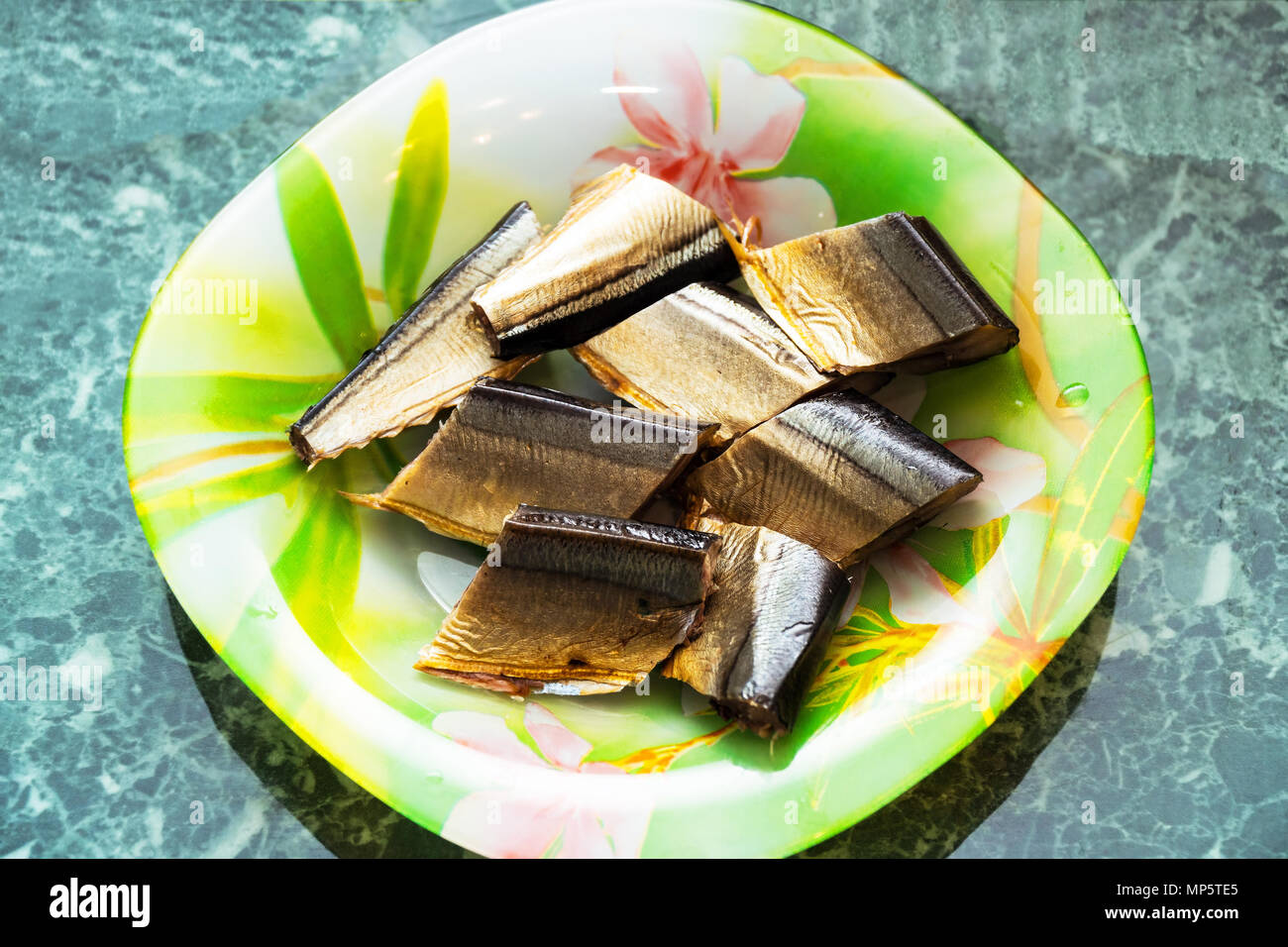 Slices of smoked saury fish on plate Stock Photo - Alamy