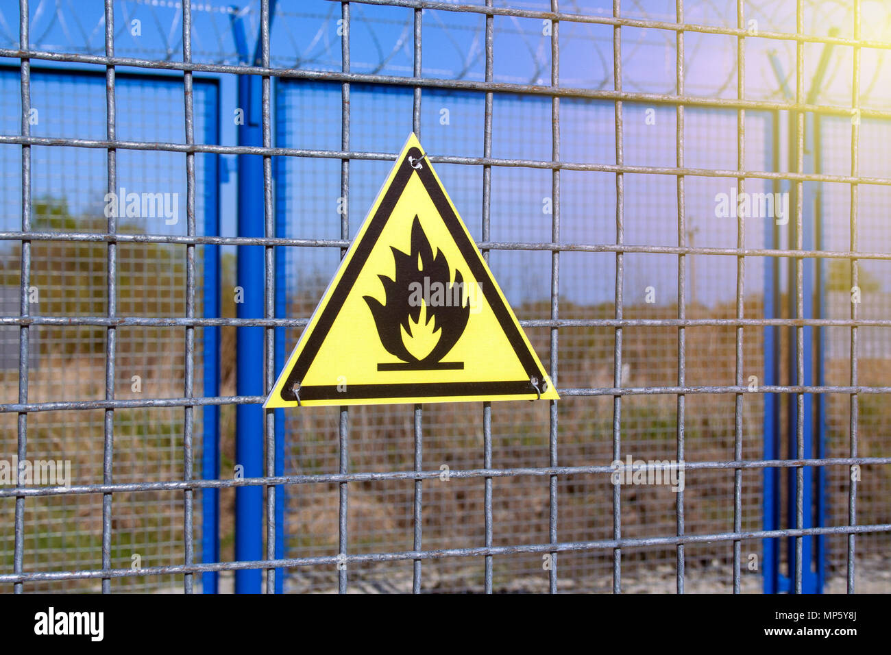 Fire danger yellow sign on metallic grid Stock Photo - Alamy