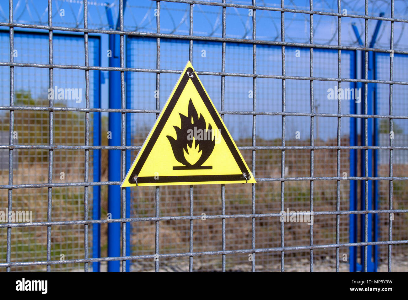Fire danger yellow sign on metallic grid Stock Photo - Alamy
