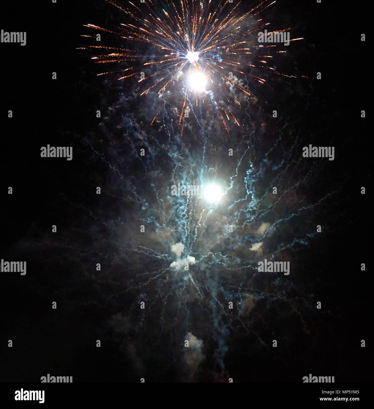 Bright golden fireworks with a smoke clouds and the bright flashes of ...