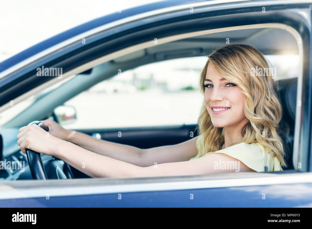 Attractive young woman driving a car Stock Photo - Alamy