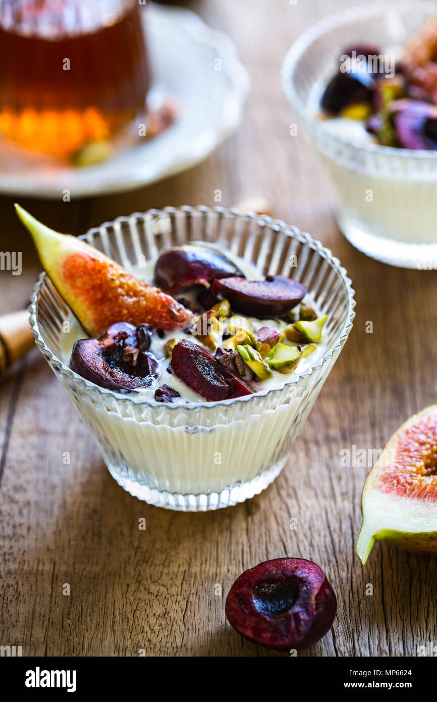 Cherry, Fig and Pistachio on Greek yogurt by Honey jar Stock Photo - Alamy