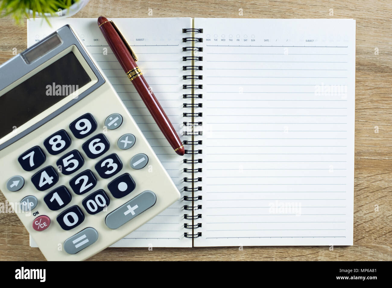 Fountain pen or ink pen with notebook paper and calculator on wooden ...
