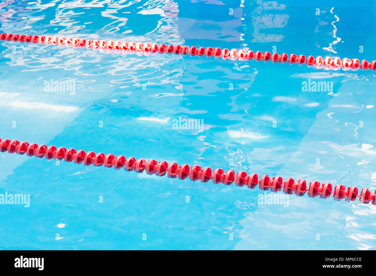 Blue pool water and red swimming lane marker in swimming pool with sun ...