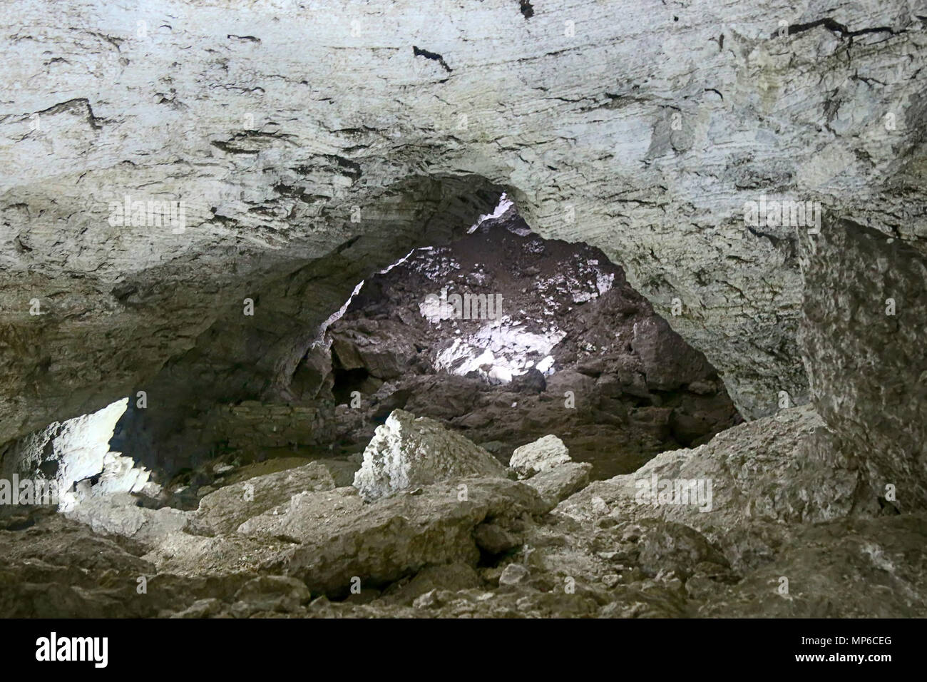 Half-filled with rock and clay natural cave. After collapse of ...