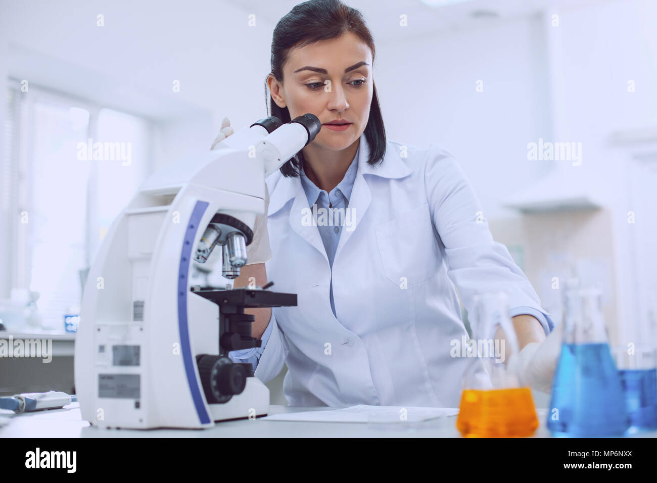 Professional female biologist working with a microscope Stock Photo - Alamy