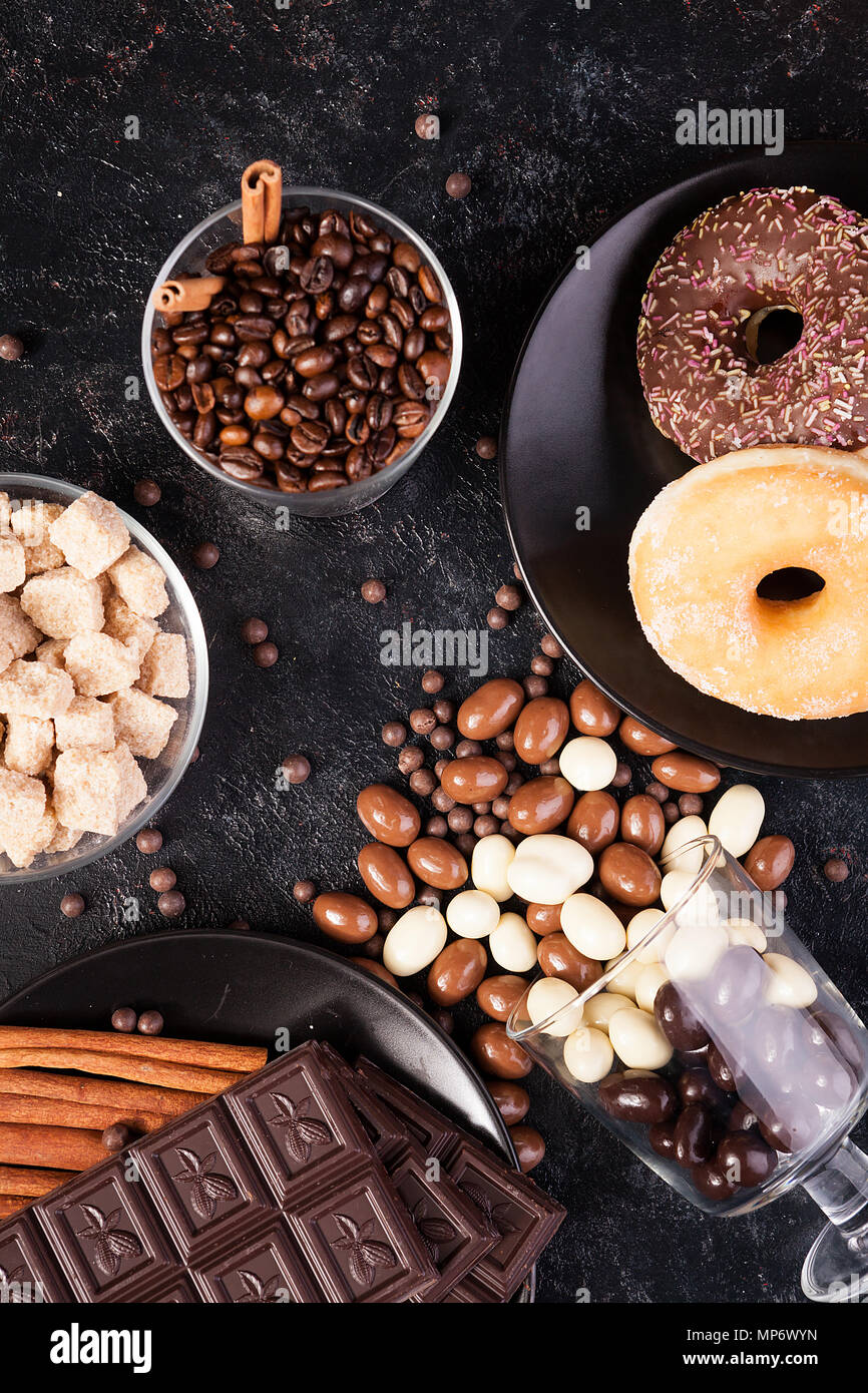 Top view of peanuts in chocolate, spilled on the dark board, next to ...