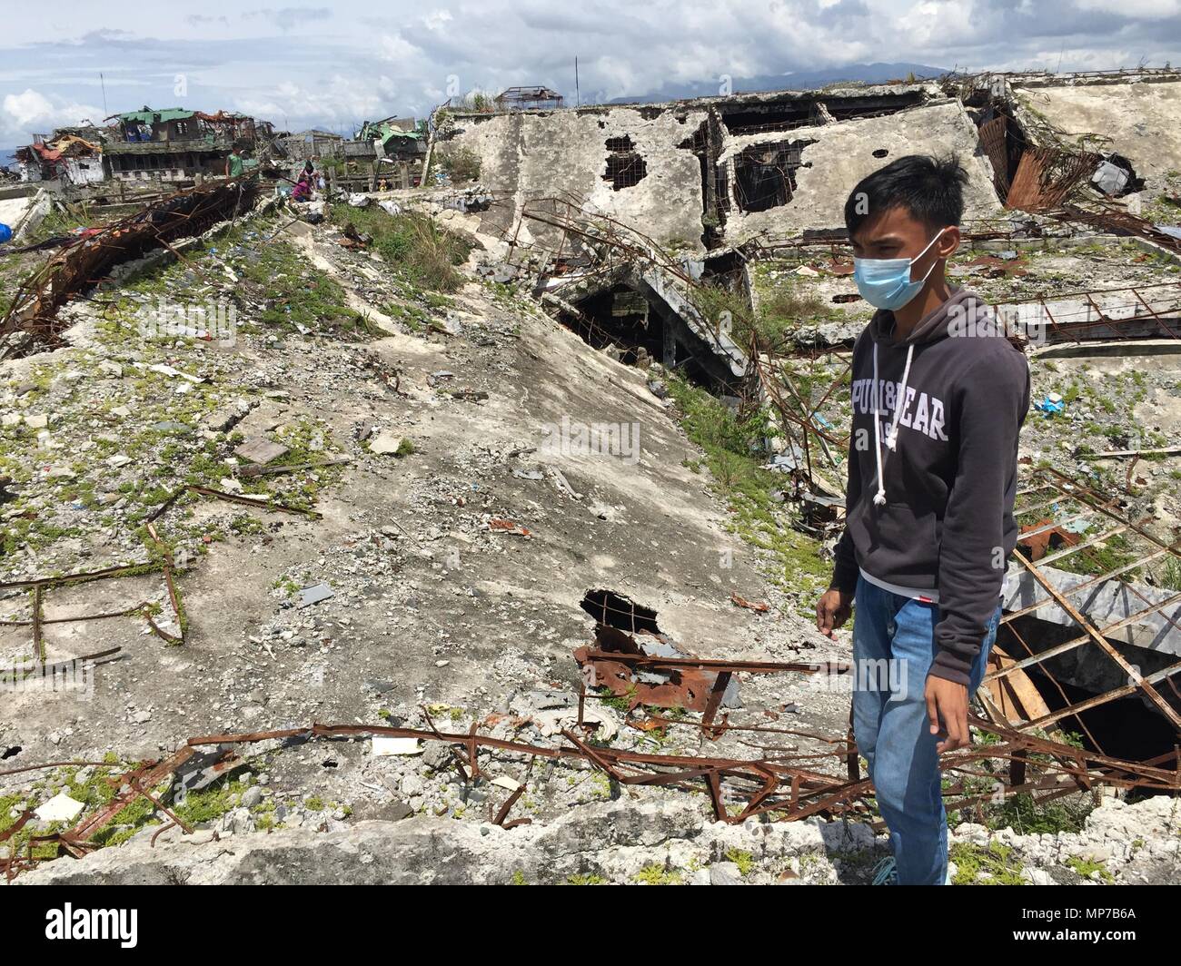 08 May 2018, Philippines, Marawi: A man stands on top of a collapsed ...