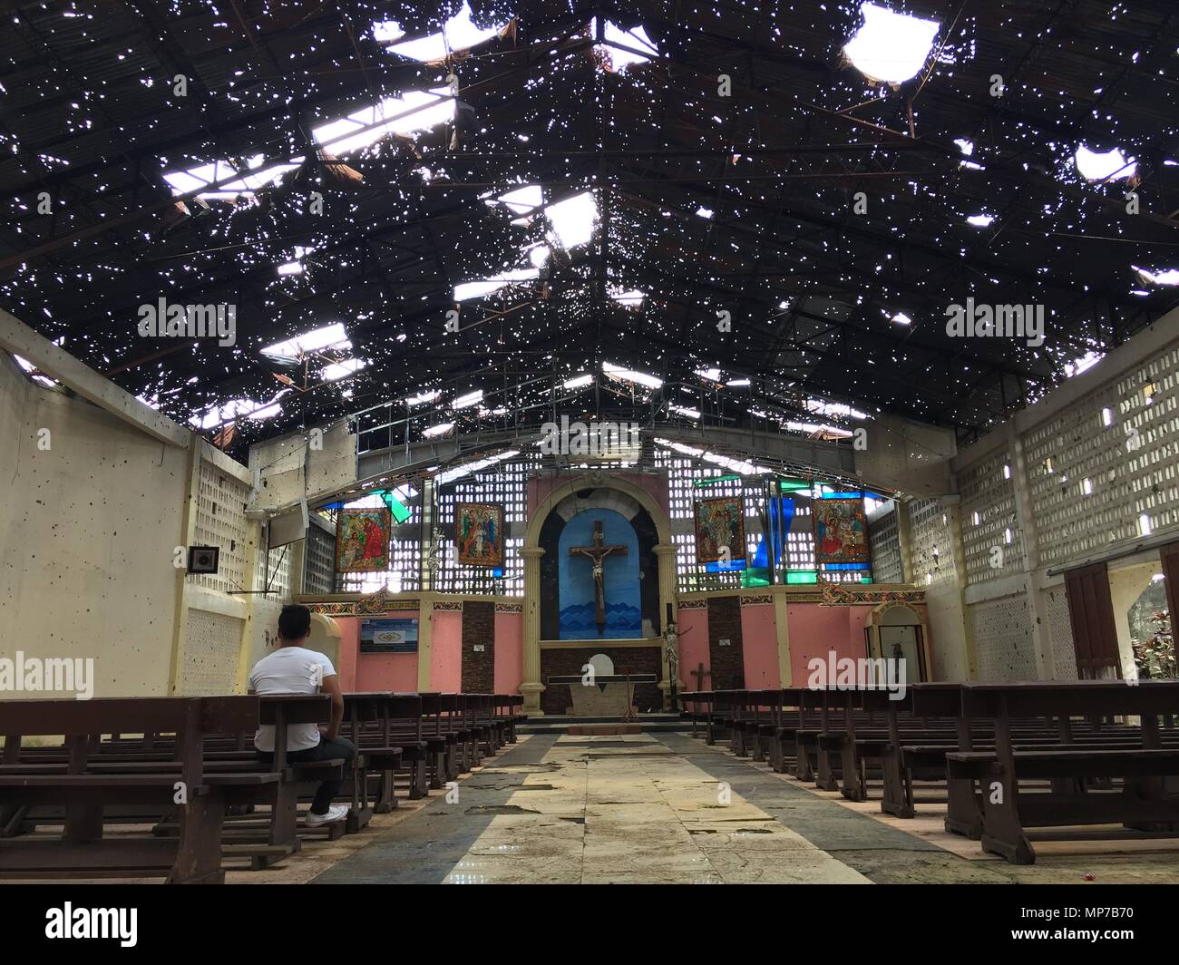 08 May 2018, Philippines, Marawi: A man sits on a pew inside the ...