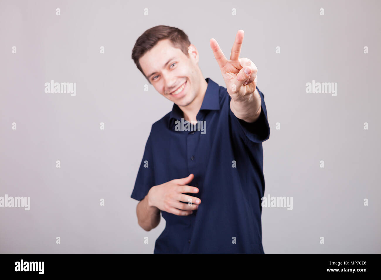 Cool positive guy showing peace sign Stock Photo - Alamy