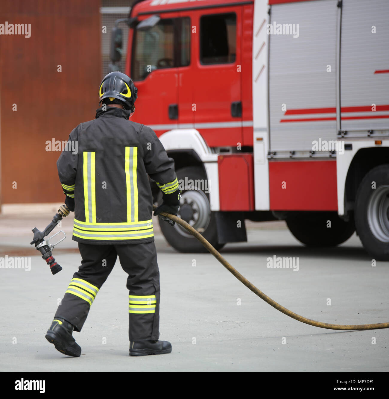 fireman with a water hose after extinguishing a big fire Stock Photo ...