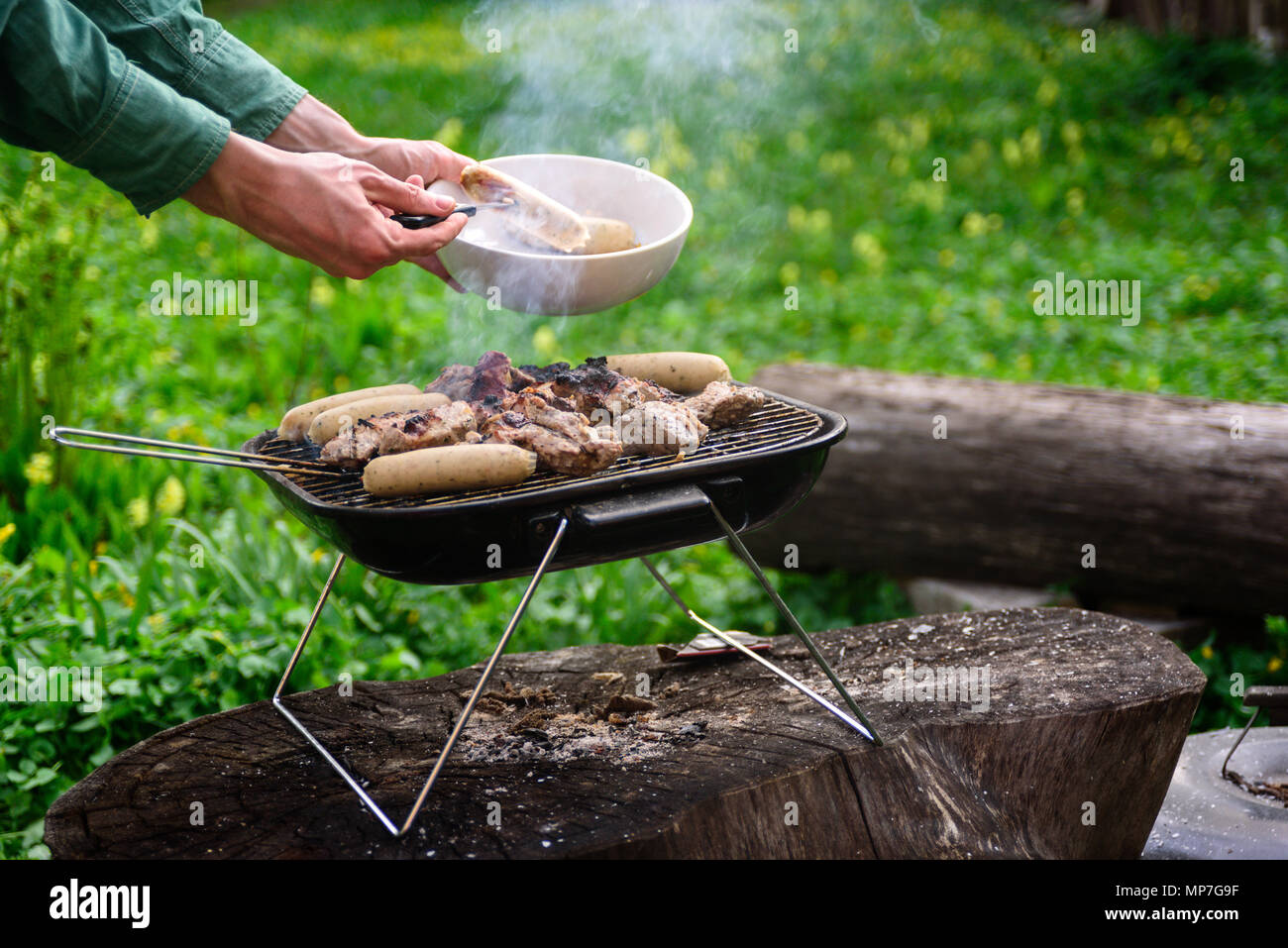 Man hands cooking bbq grill on portable grillware Stock Photo - Alamy