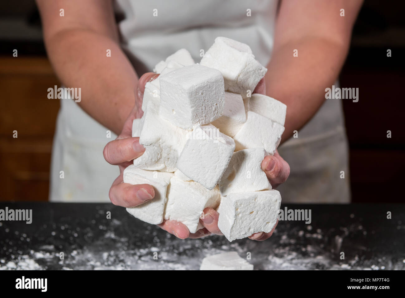 Bunch of Marshmallow Cubes in Hand over slate surface Stock Photo - Alamy