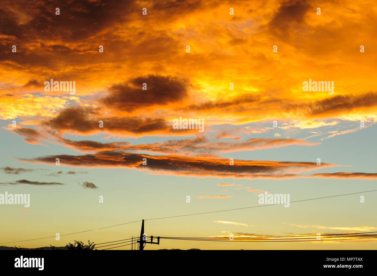 Glorious golden cloud in beautiful blue sky at dusk. With light pole ...