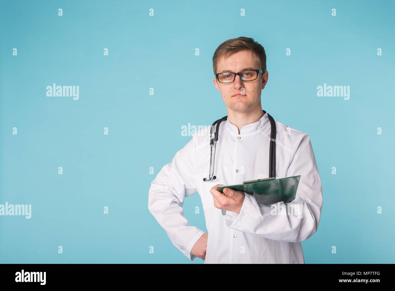 Medical doctor writing prescription over blue background with copy ...