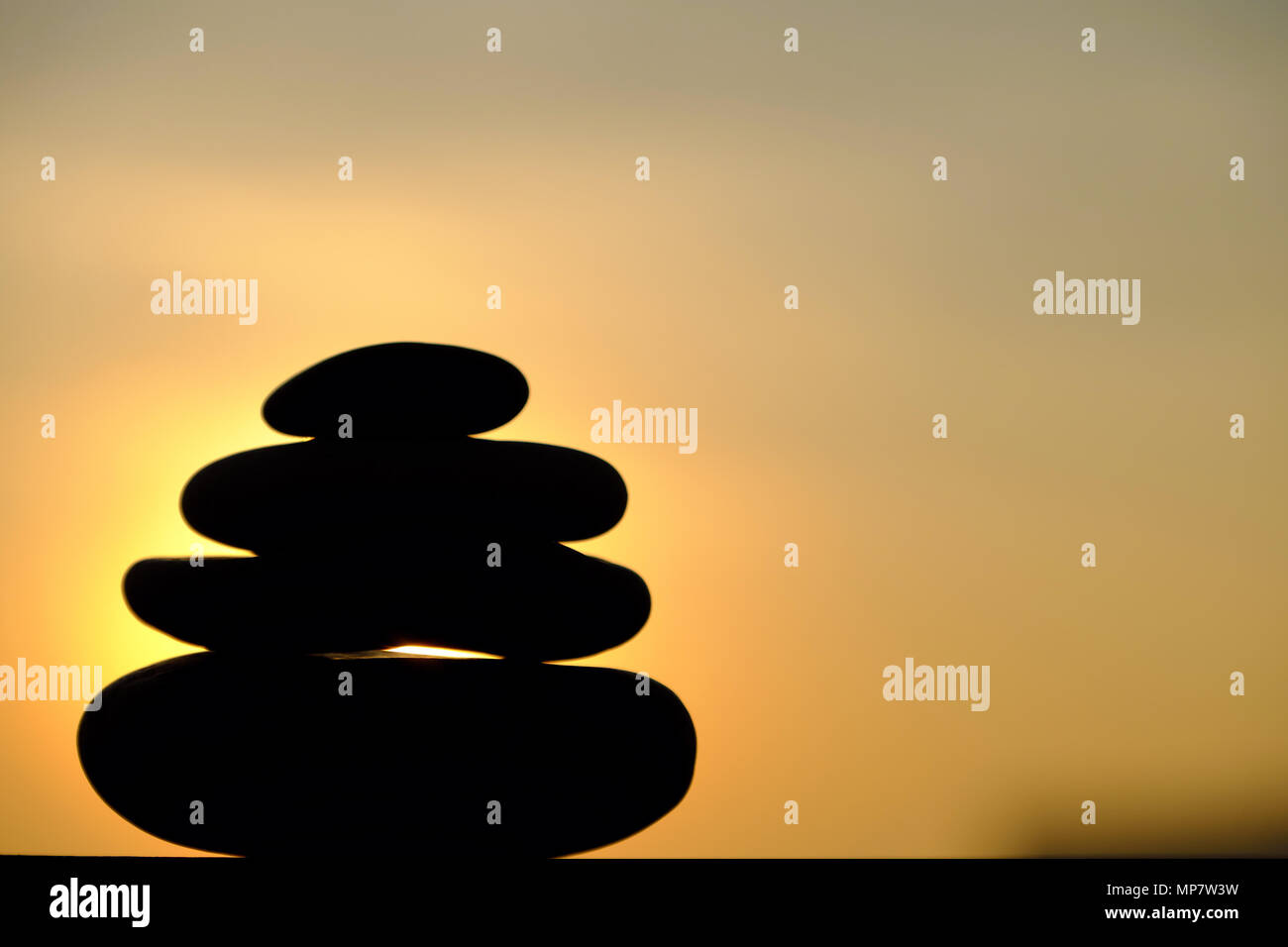 Amazing shape of stack of pebble on yellow sun background at sunrise ...